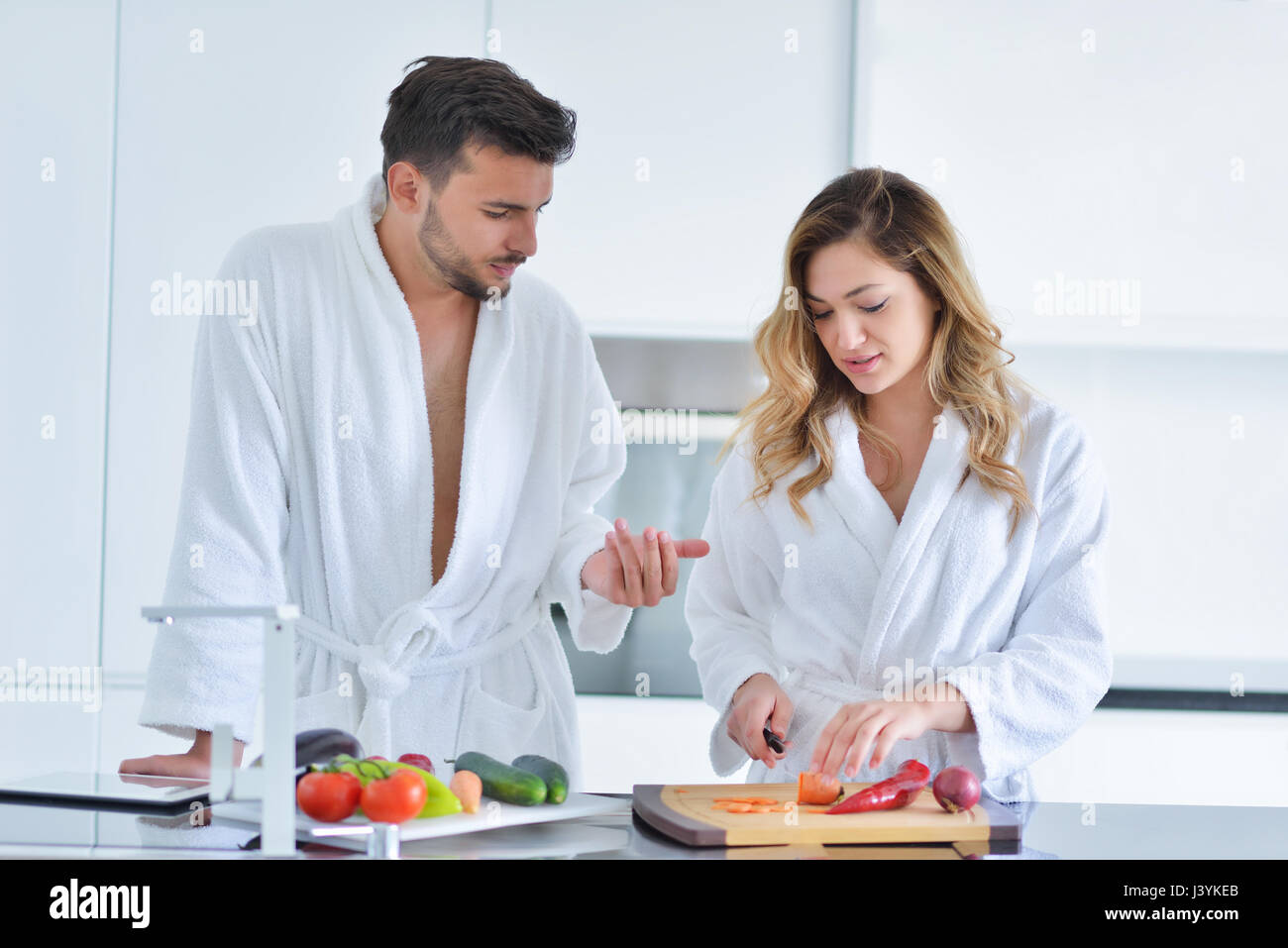 Happy couple cooking breakfast together in the kitchen Stock Photo - Alamy