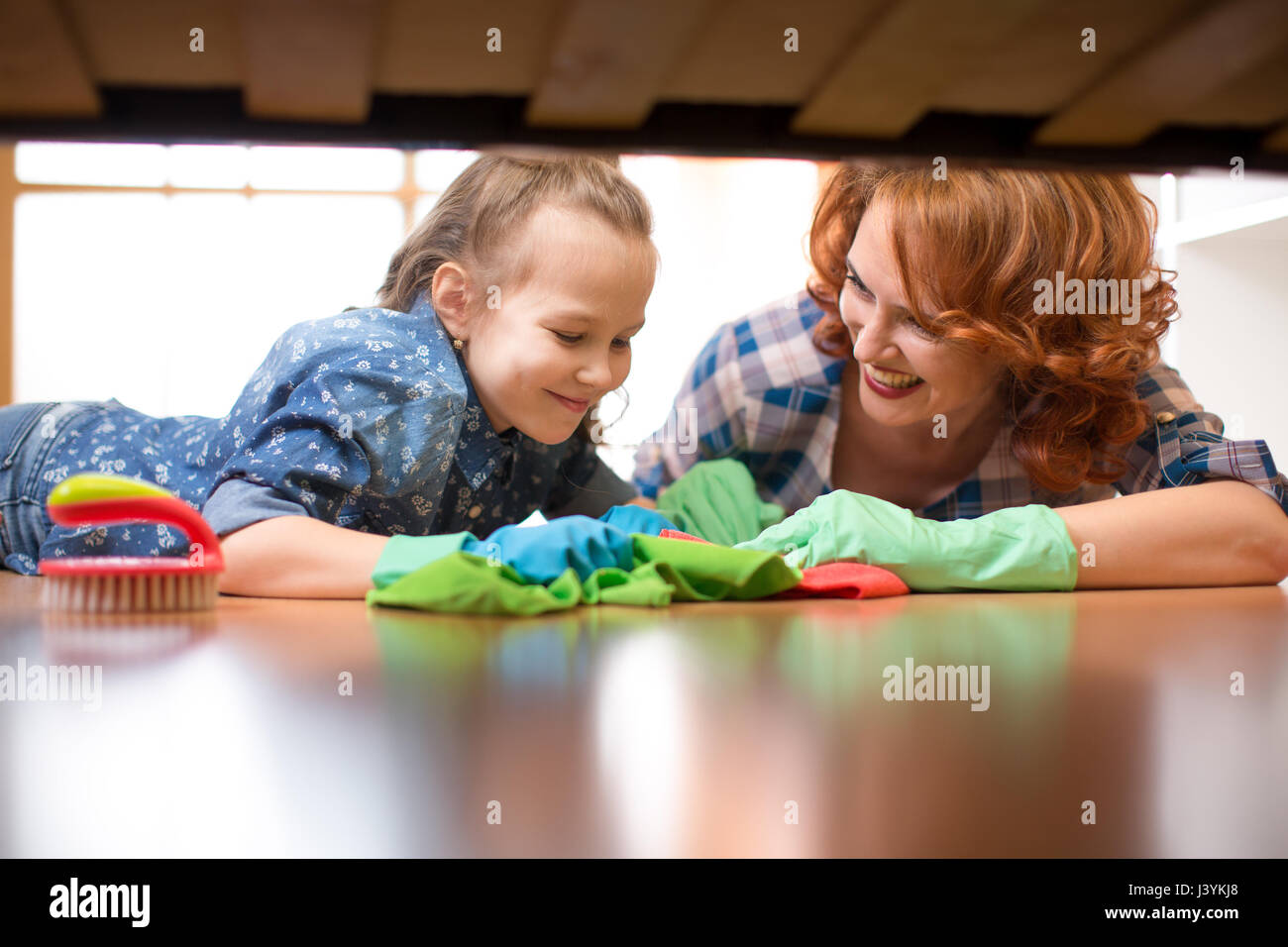 Smiling family mother and child girl clean room at home. Middle-aged ...