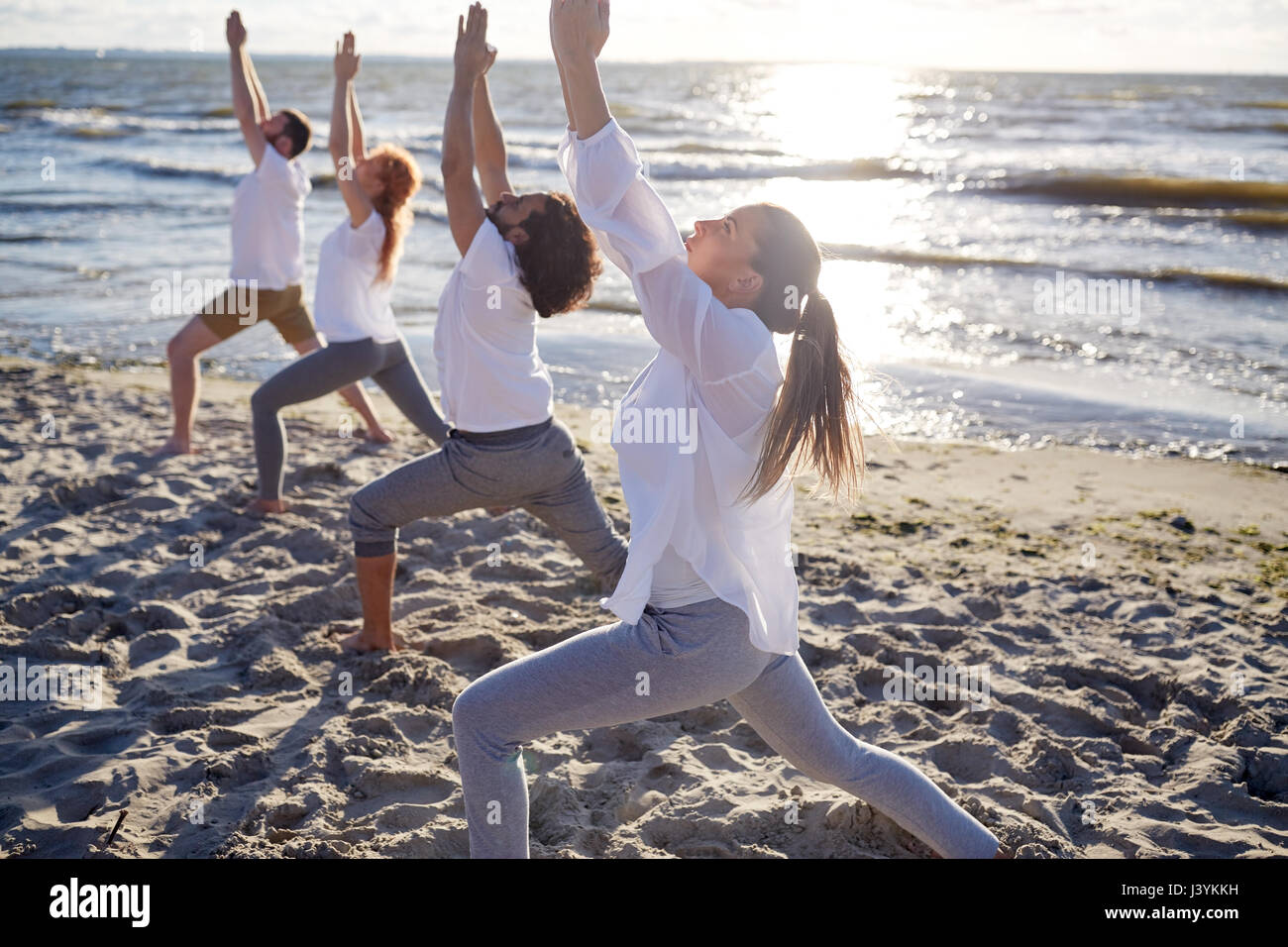 group of people making yoga exercises on beach Stock Photo - Alamy