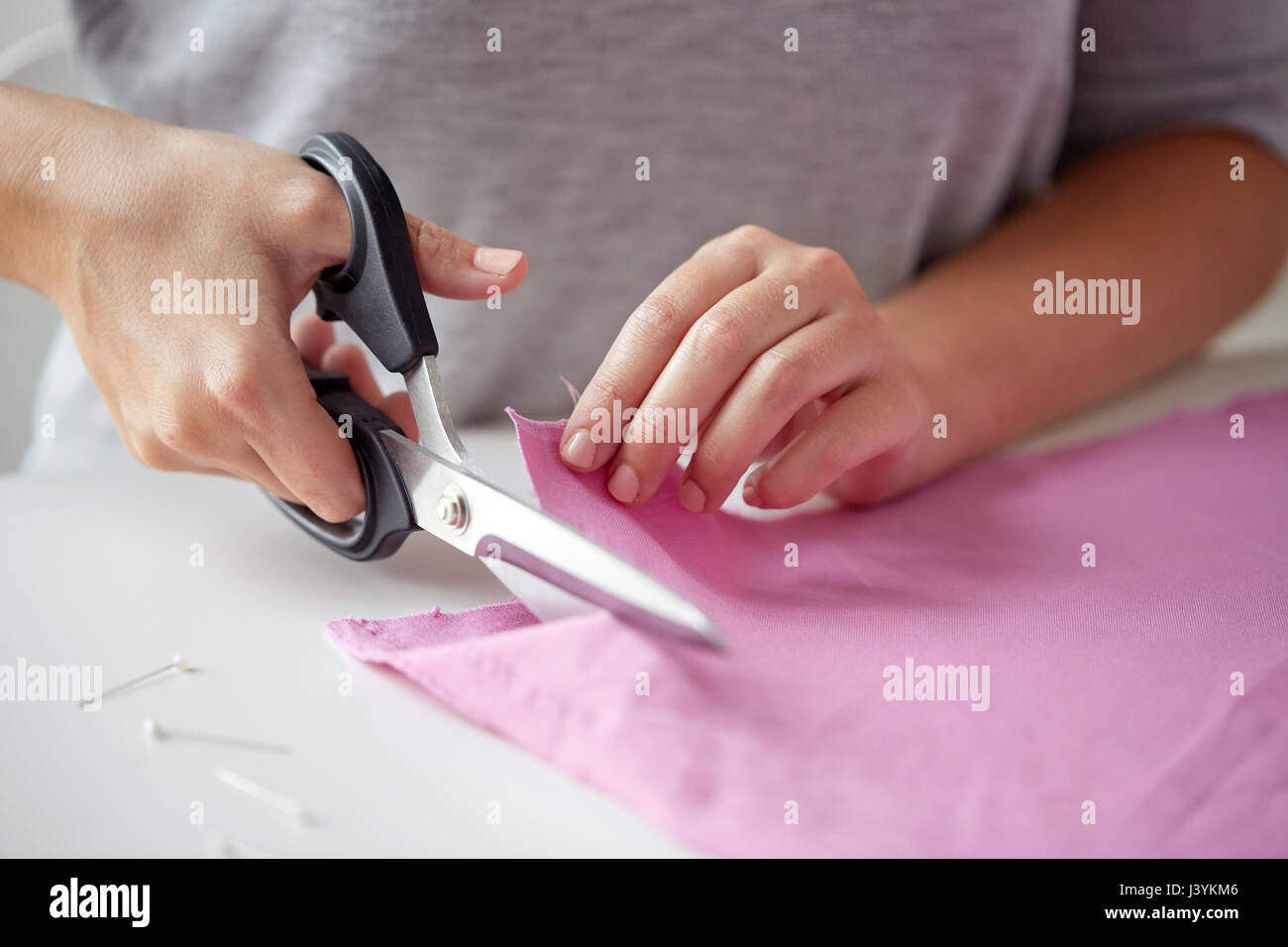woman with tailor scissors cutting out fabric Stock Photo - Alamy