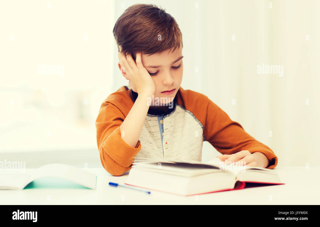 student boy reading book or textbook at home Stock Photo - Alamy