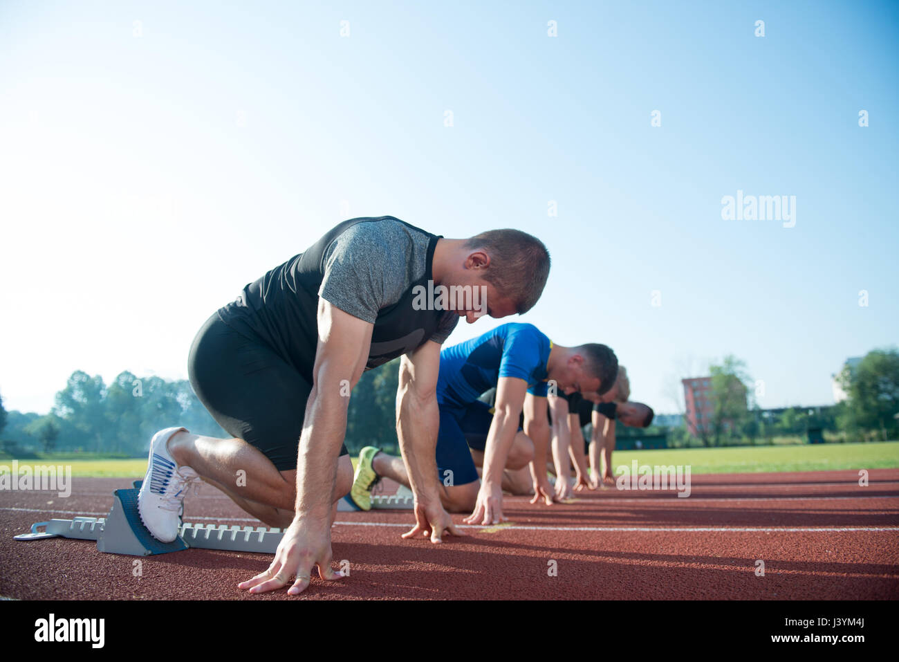 Runners preparing for race at starting blocks Stock Photo - Alamy