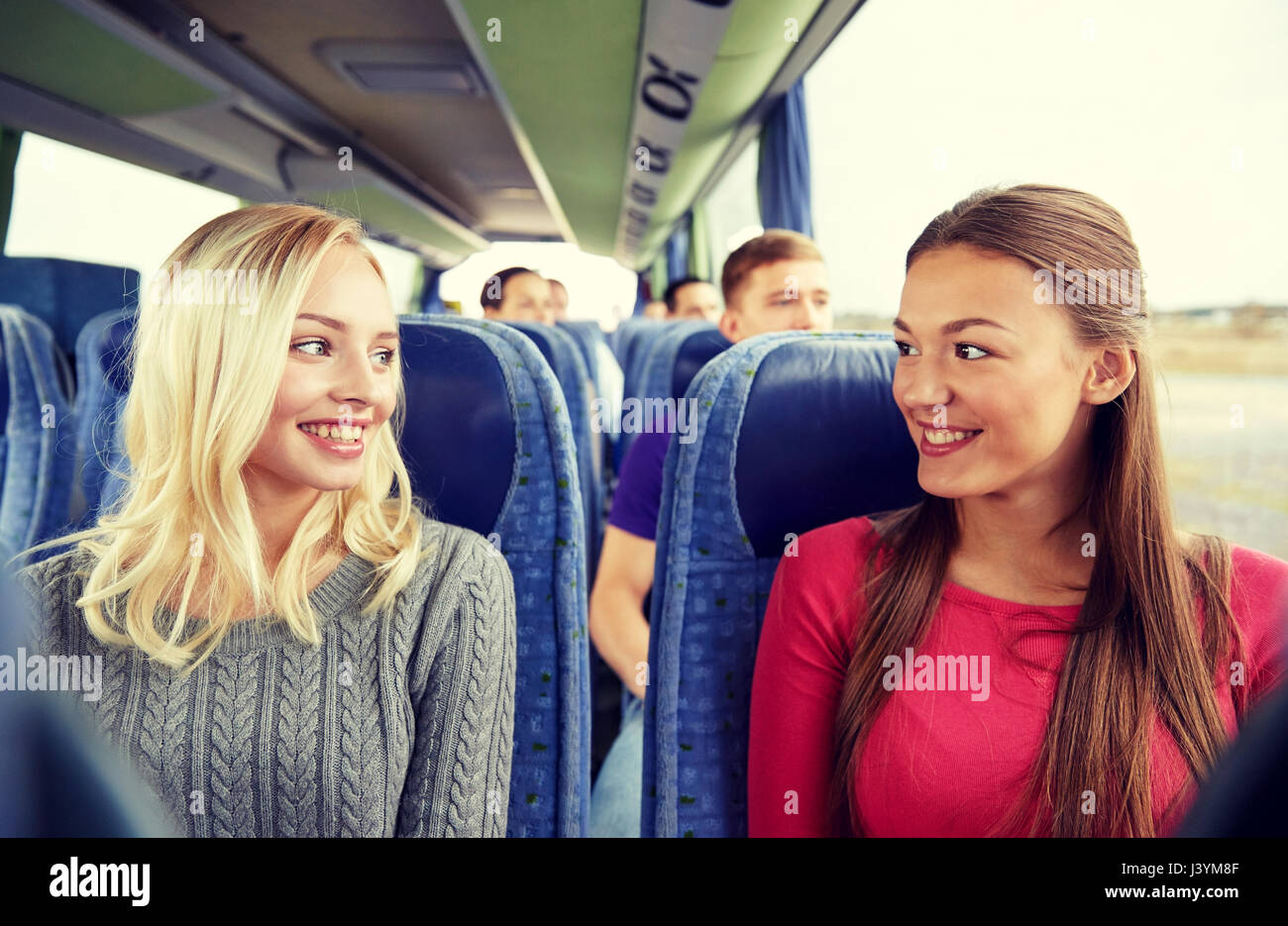 happy young women talking in travel bus Stock Photo - Alamy