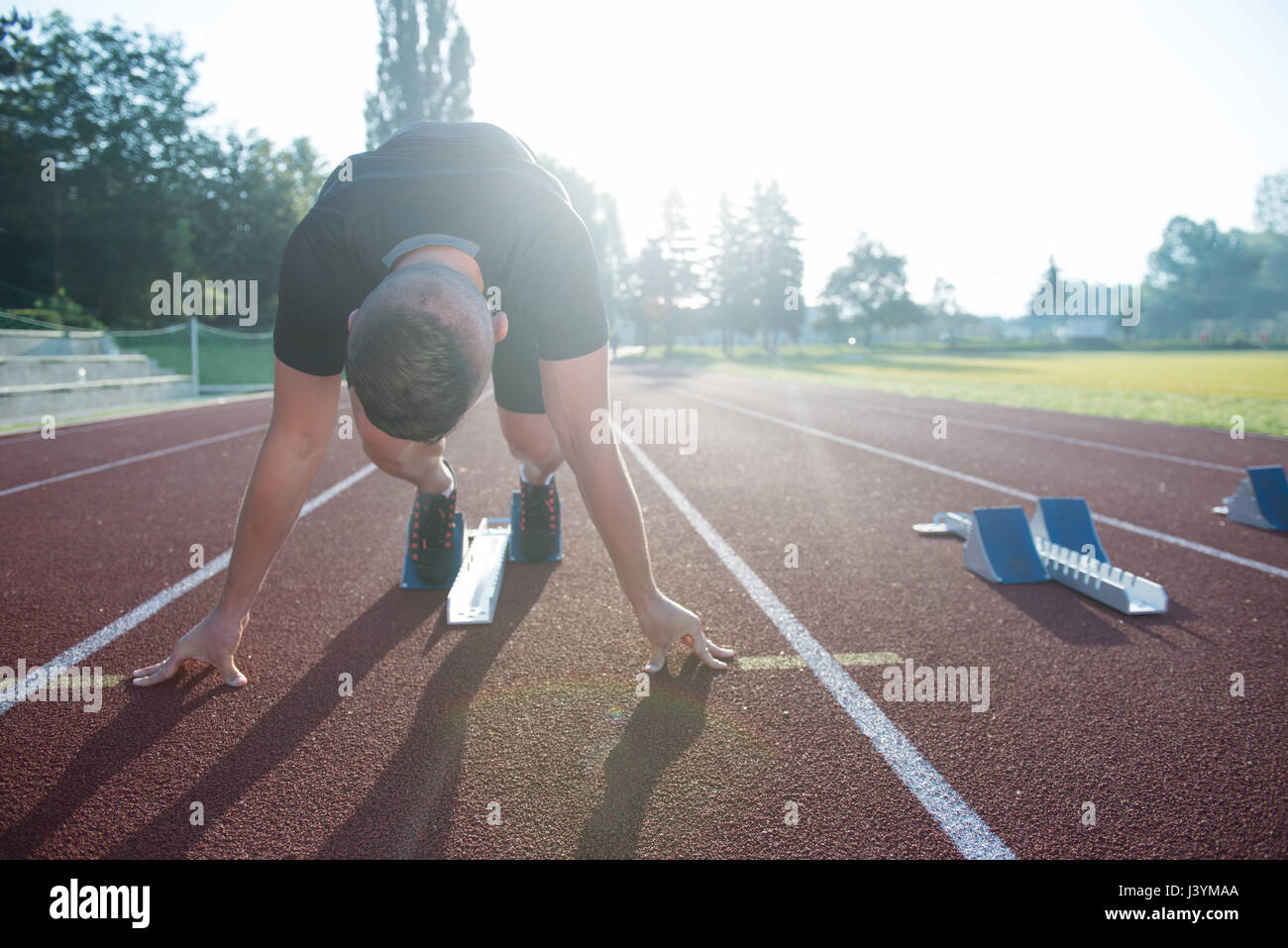 Sprinter leaving starting blocks on the running track. Explosive start ...