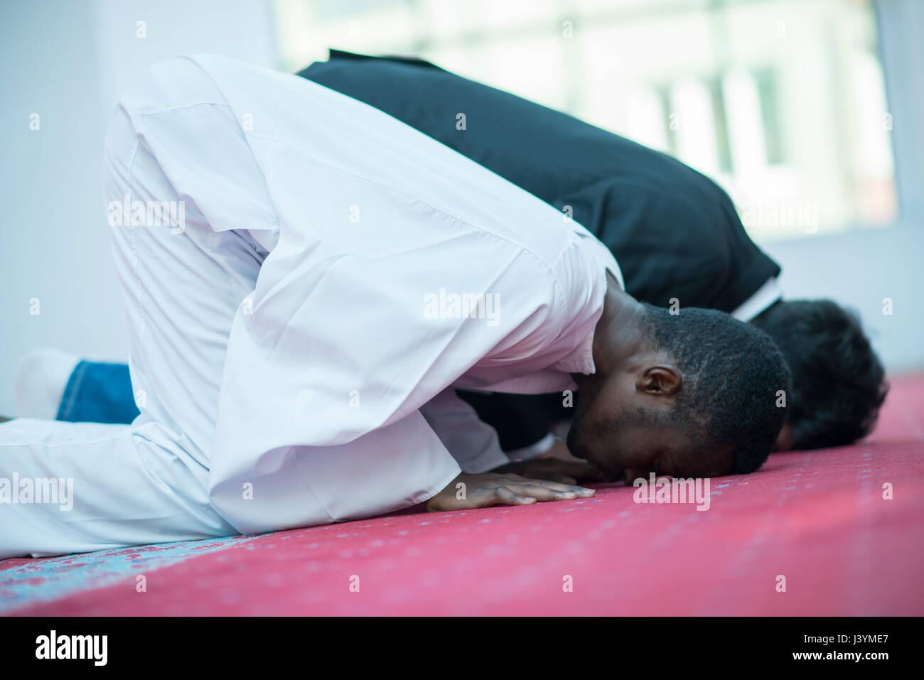 Two religious muslim man praying together inside the mosque Stock Photo ...