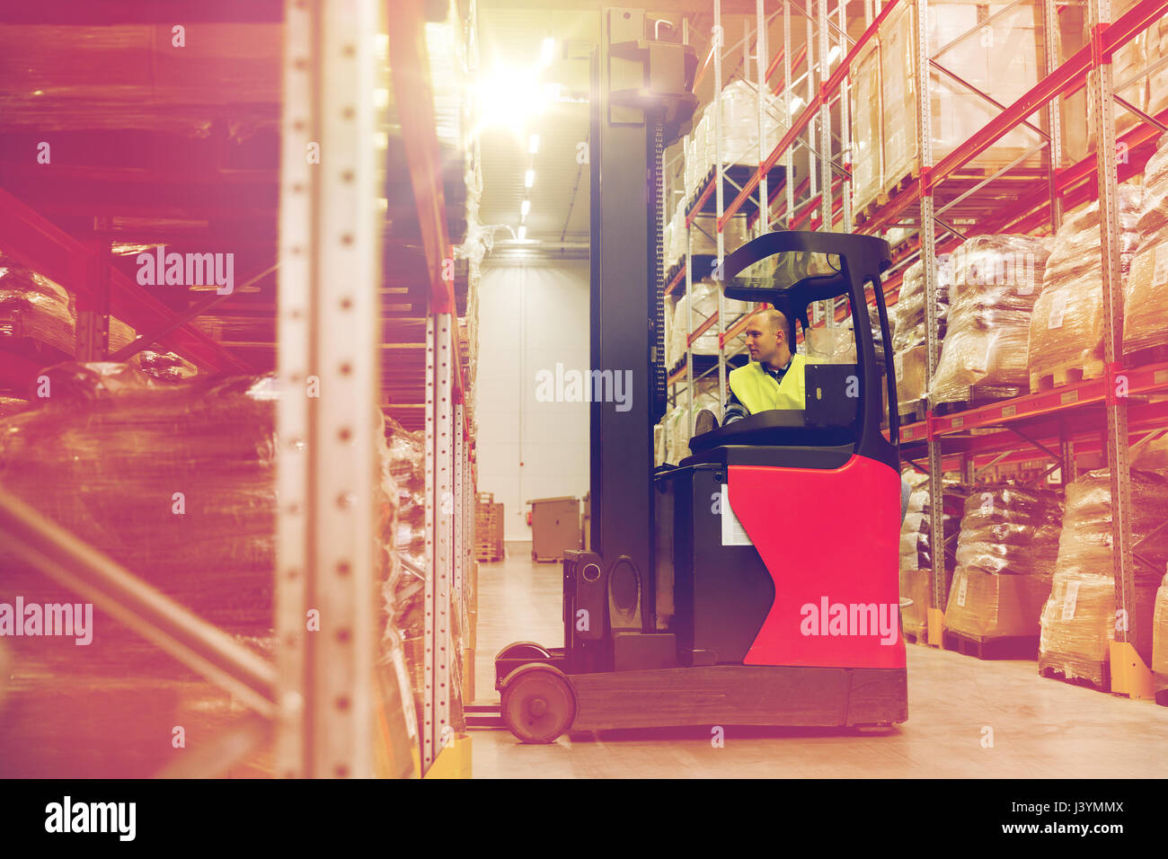man on forklift loading cargo at warehouse Stock Photo - Alamy