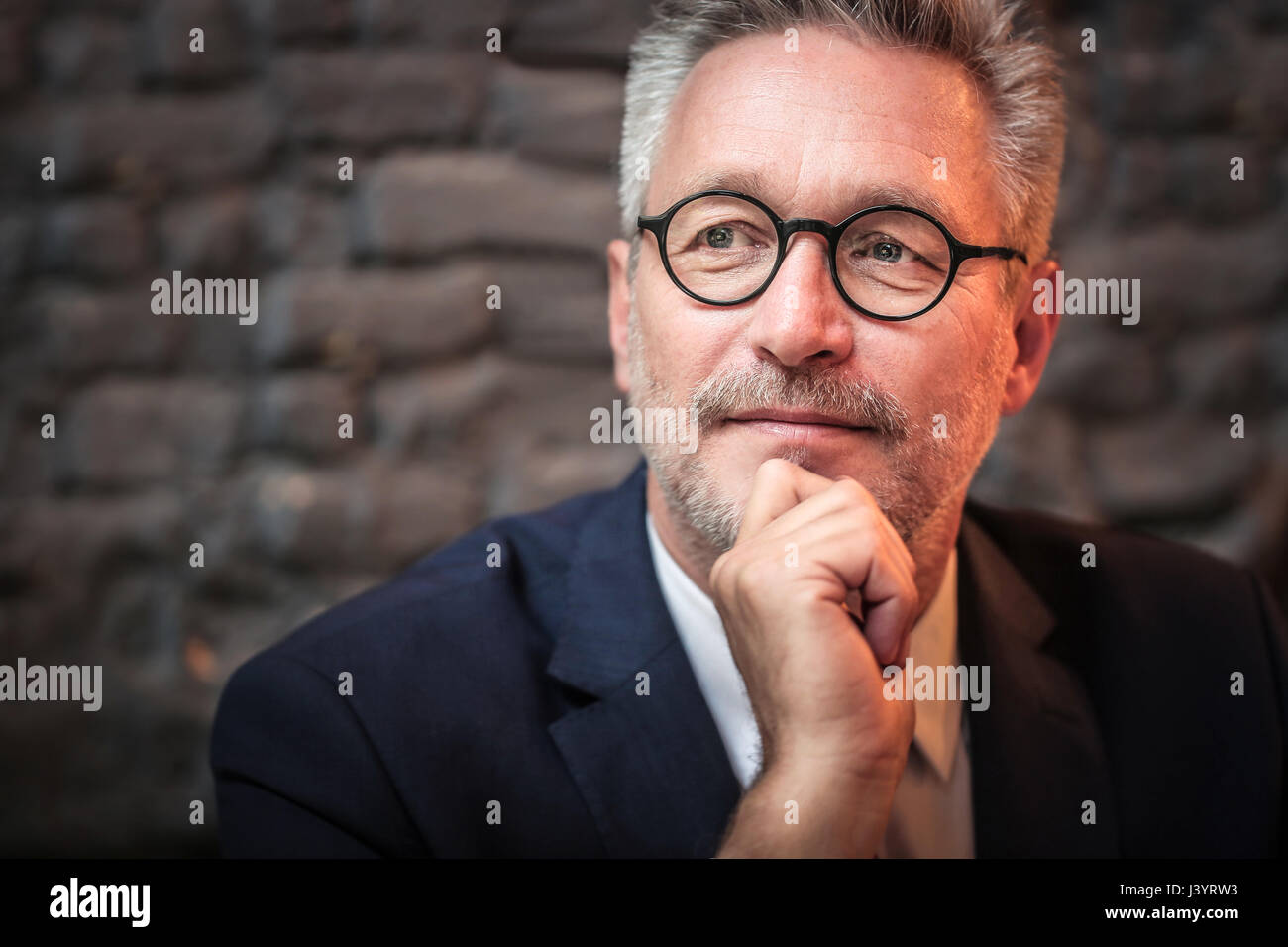 Portrait of an handsome man smiling, while thinking at the future Stock ...