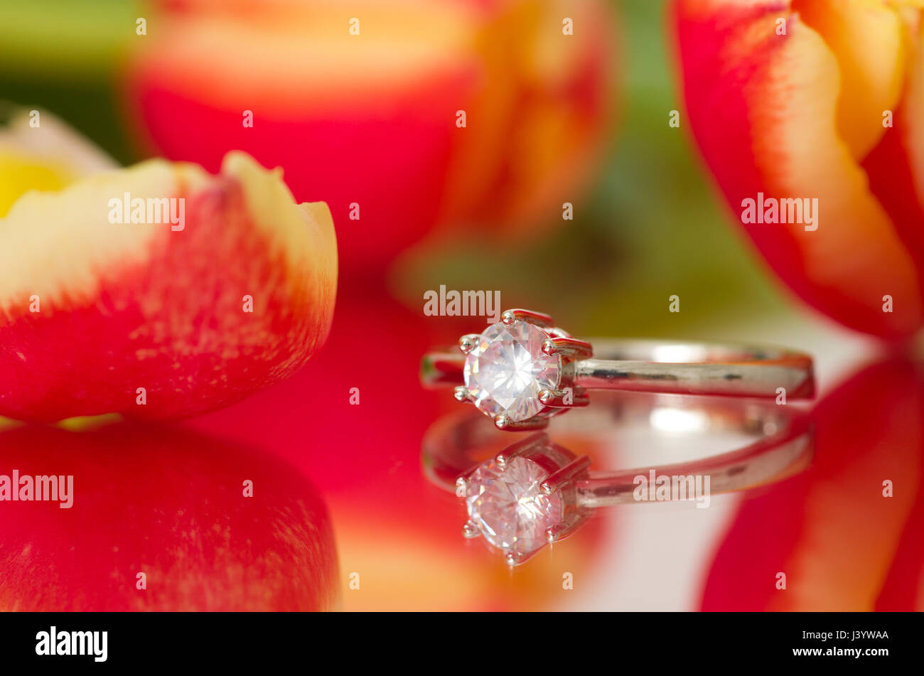 Engagement ring and flowers on a mirror surface Stock Photo - Alamy