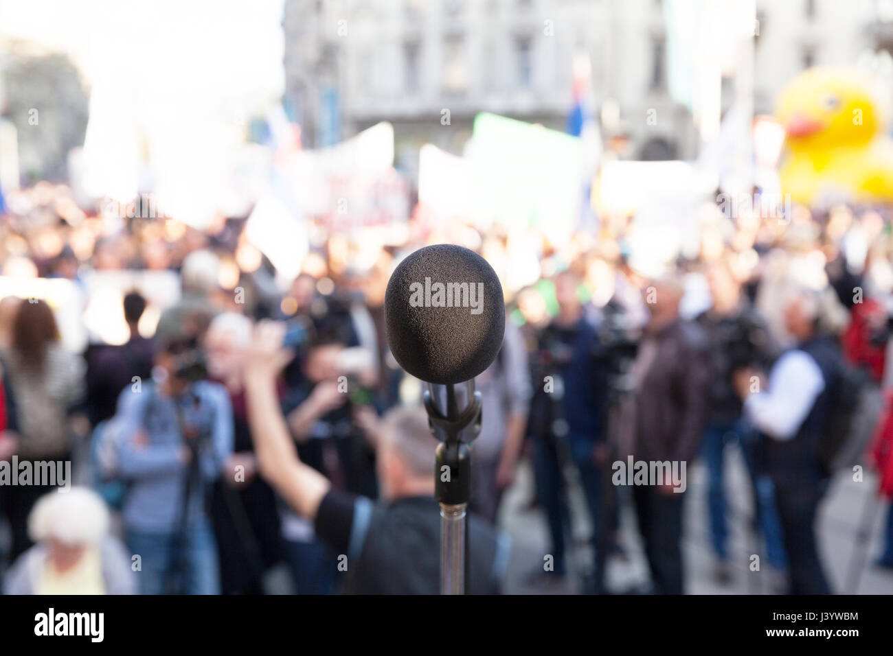 Microphone in focus, blurred crowd in background Stock Photo - Alamy