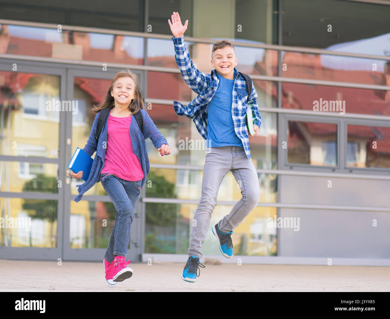Boy and girl with books and backpacks Stock Photo - Alamy