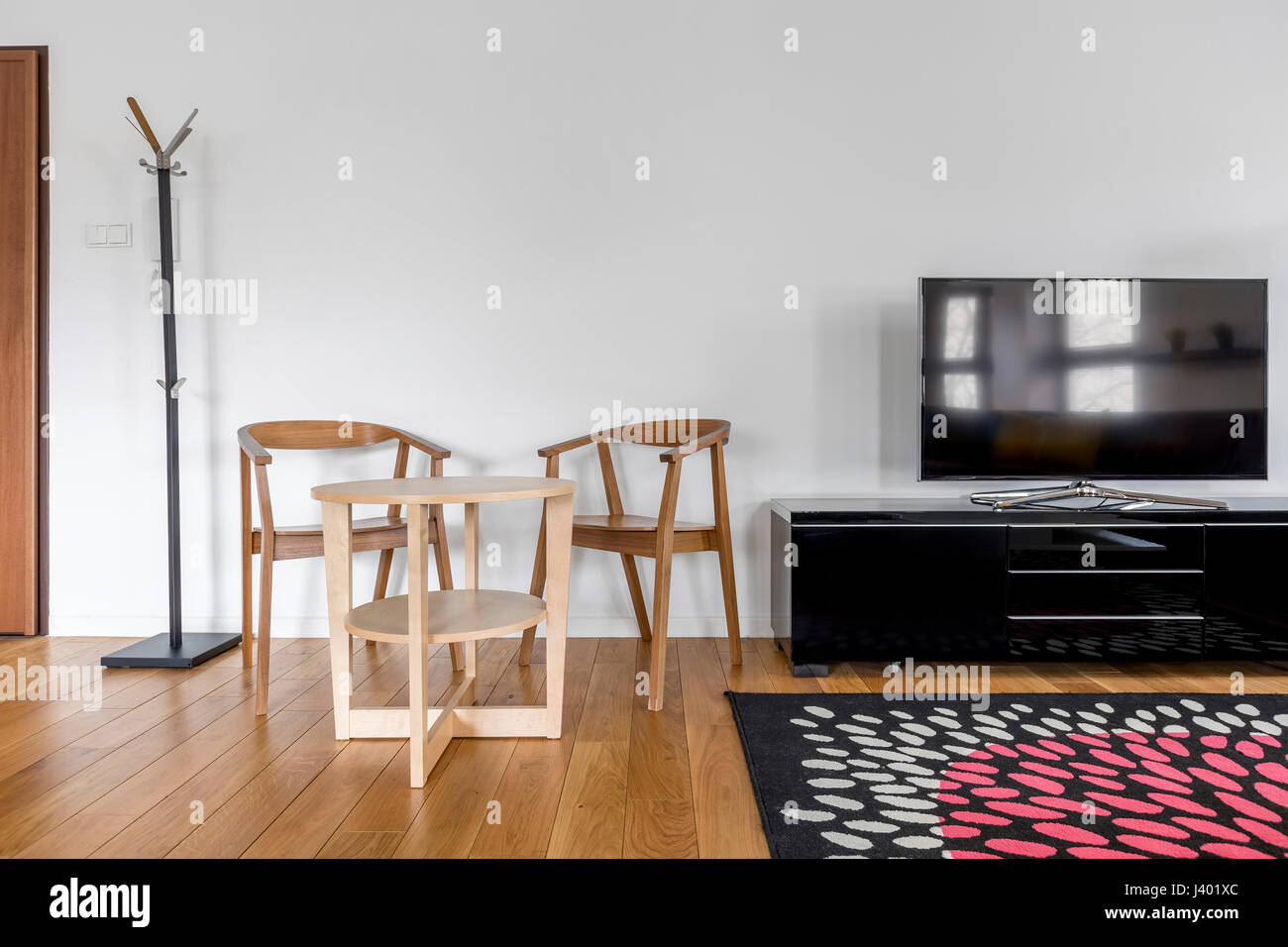 Wooden chairs and table in leisure room with tv screen Stock Photo - Alamy