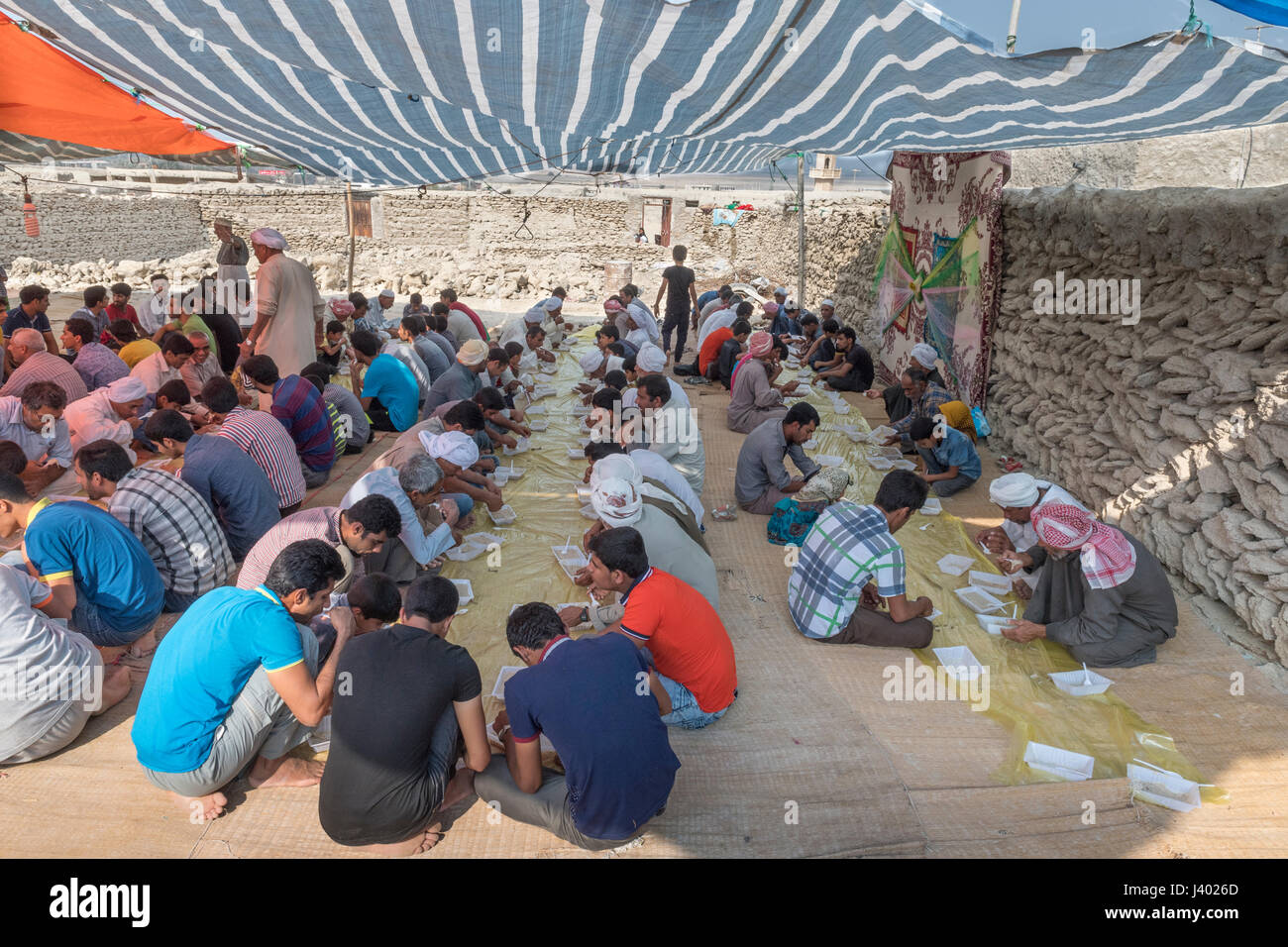 Men Eating Halim -local porridge- from plastic containers under tent ...
