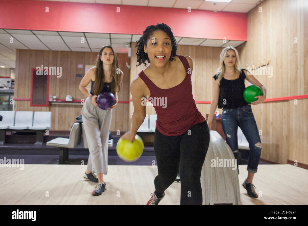 A young woman bowling with friends Stock Photo - Alamy