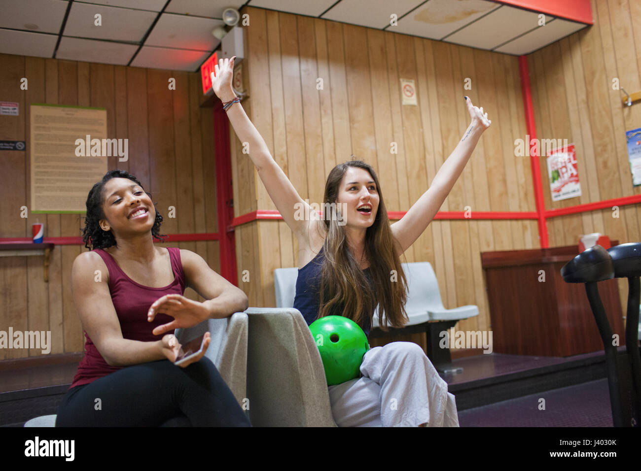 Three young women cheering at a bowling alley Stock Photo - Alamy