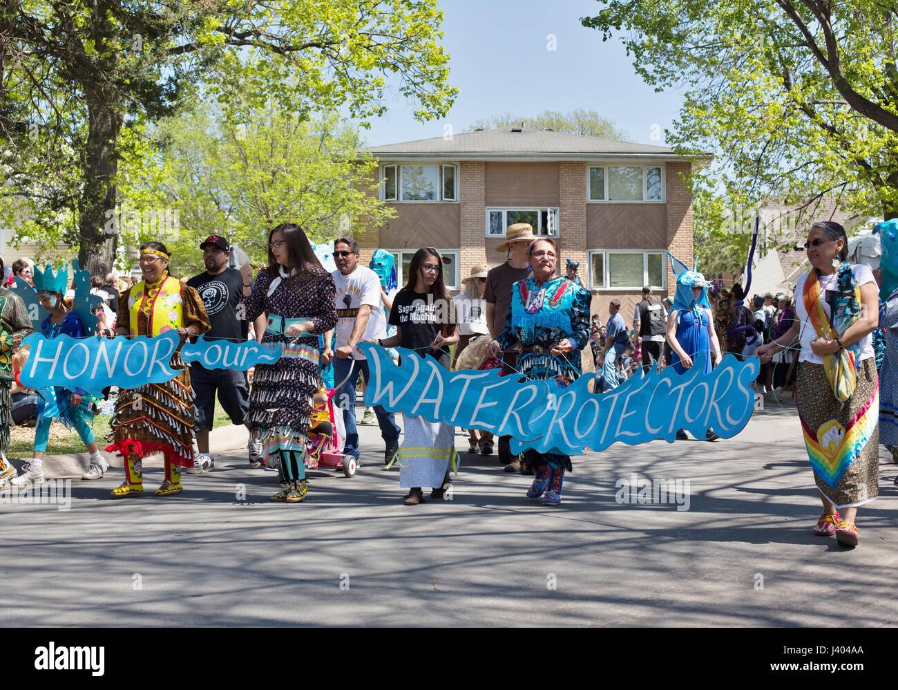 A group of Native American women marching with a banner that reads ...