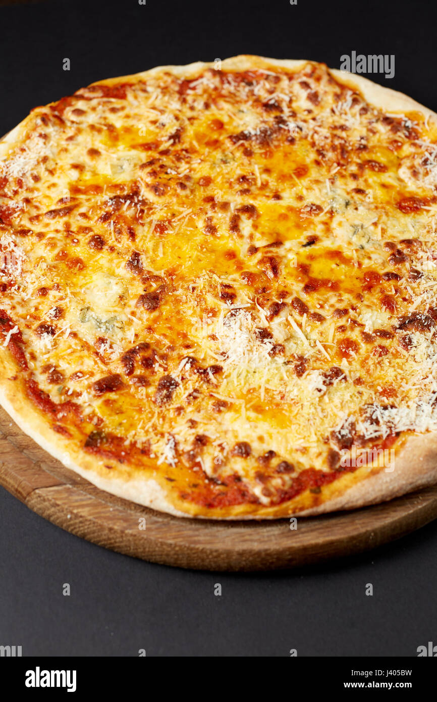 Hot pizza Quattro Formaggi on a rustic wooden table. Italian food Stock Photo - Alamy