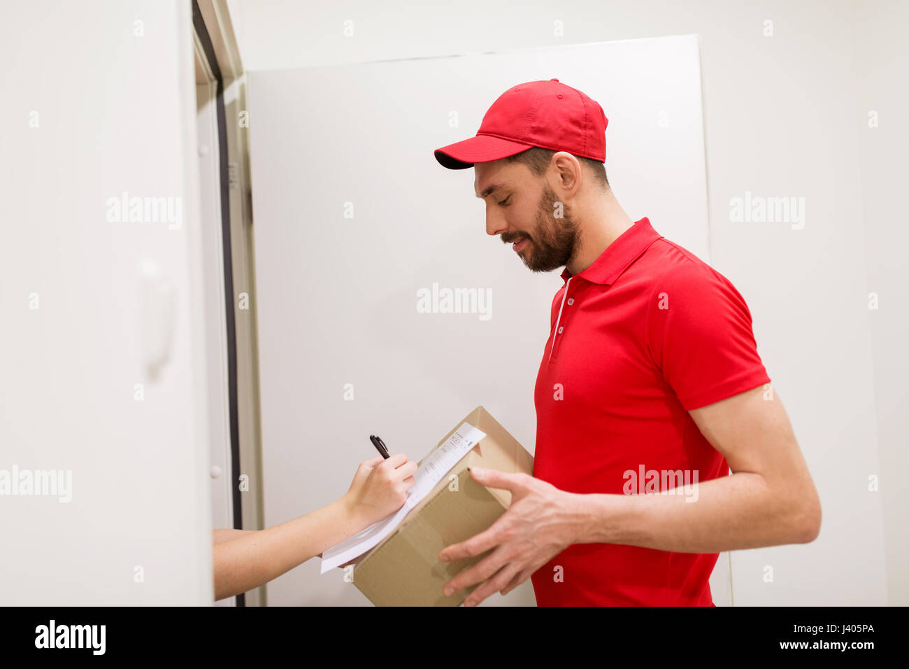 delivery man with box and customer signing form Stock Photo - Alamy