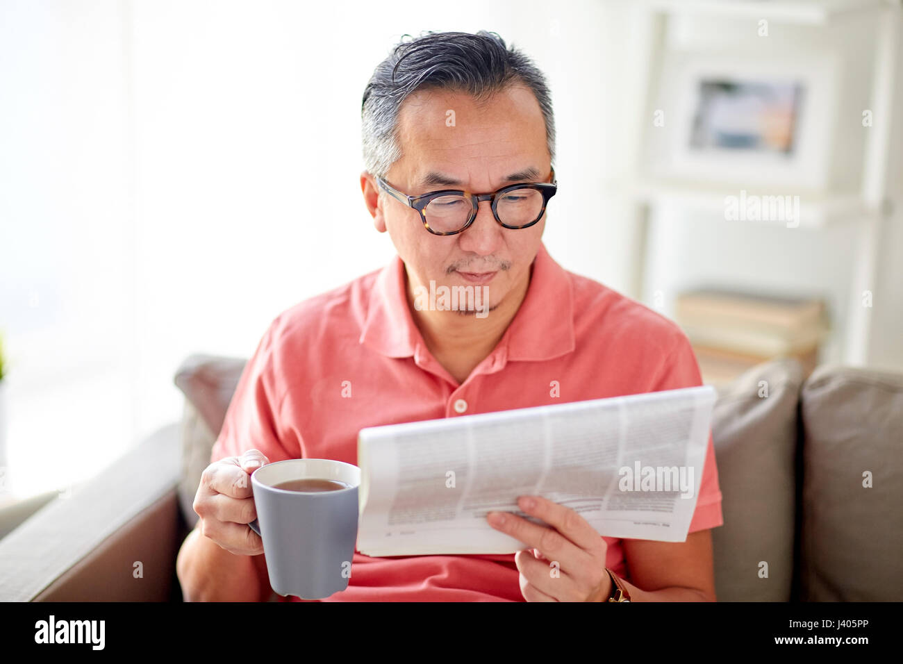 man drinking tea and reading newspaper at home Stock Photo - Alamy