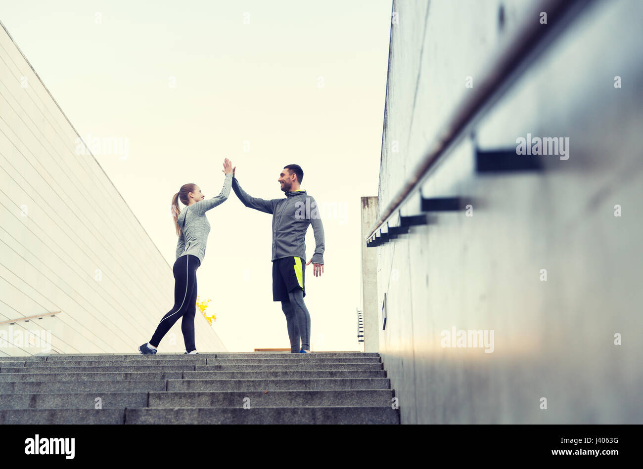 smiling couple making high five on city street Stock Photo - Alamy
