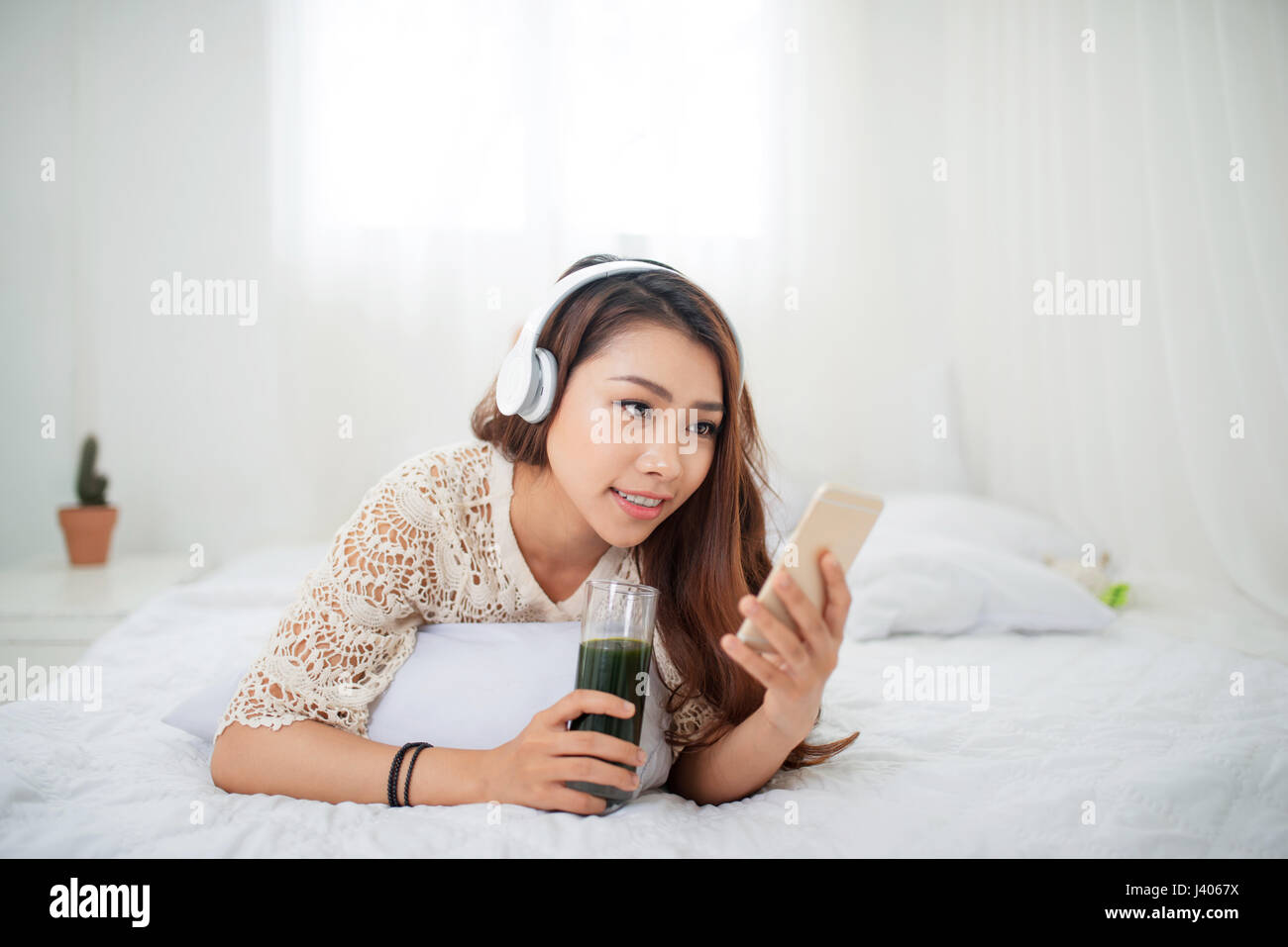 Woman Relaxing in bed and using mobile phone, relaxing in her living ...