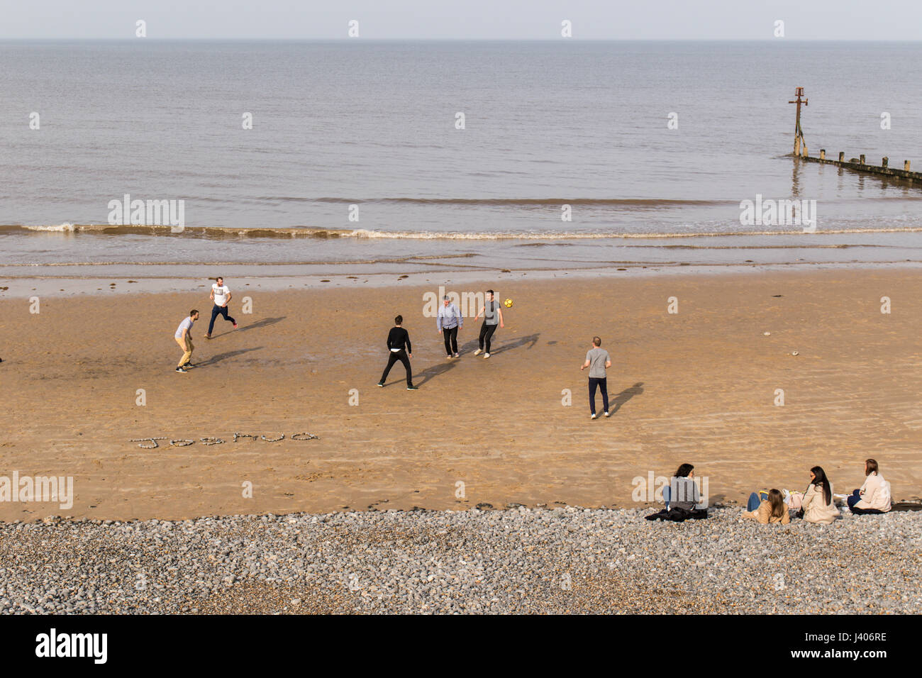 Six young men playing football soccer on the beach including a name ...