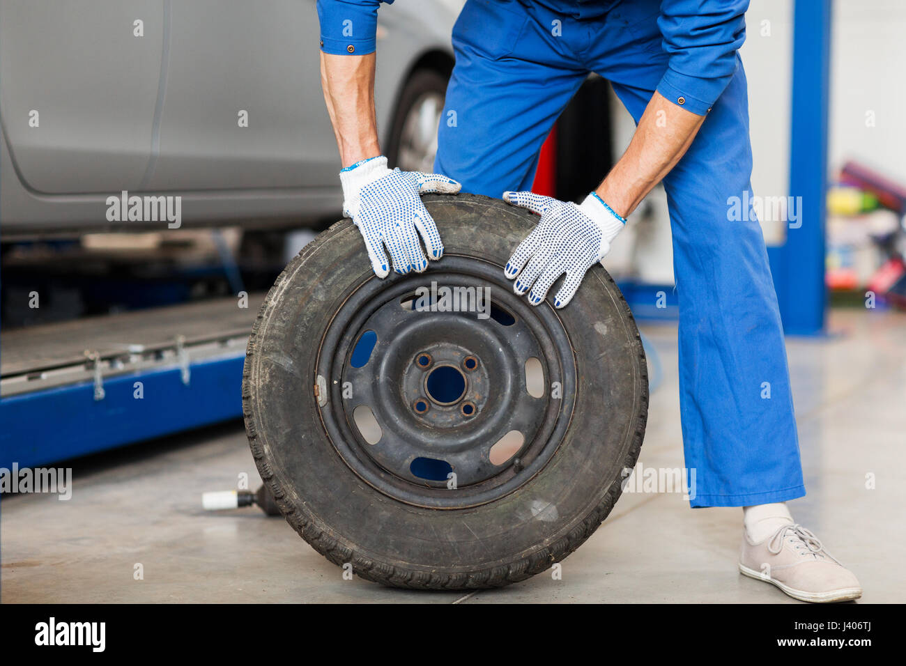 mechanic with wheel tire at car workshop Stock Photo - Alamy