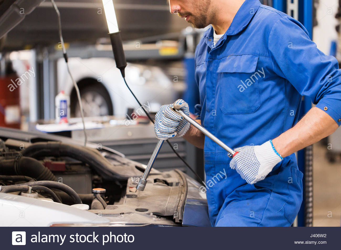 mechanic man with wrench repairing car at workshop Stock Photo - Alamy