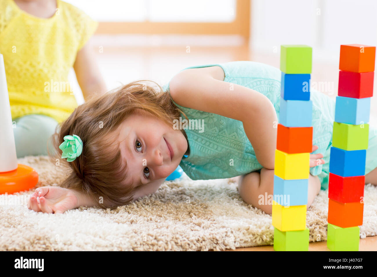 child girl playing with block toys on floor Stock Photo - Alamy