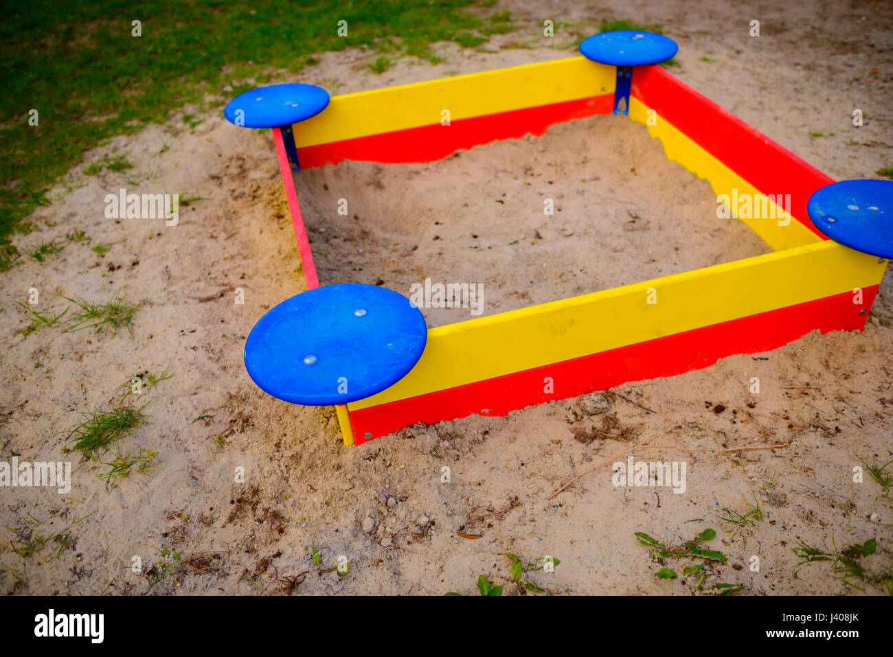 A nice sandbox playground filled . Surrounded by green grass, seen from ...