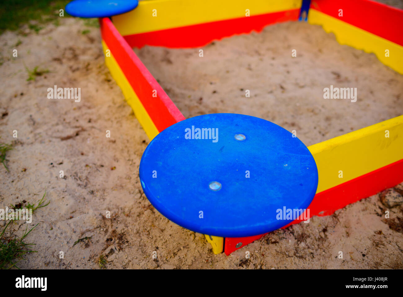 A nice sandbox playground filled . Surrounded by green grass, seen from ...
