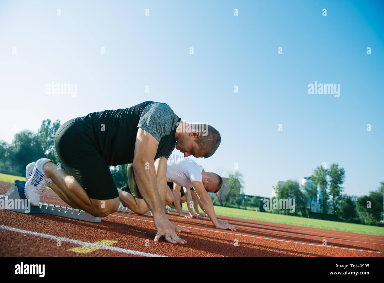 Runners preparing for race at starting blocks Stock Photo - Alamy