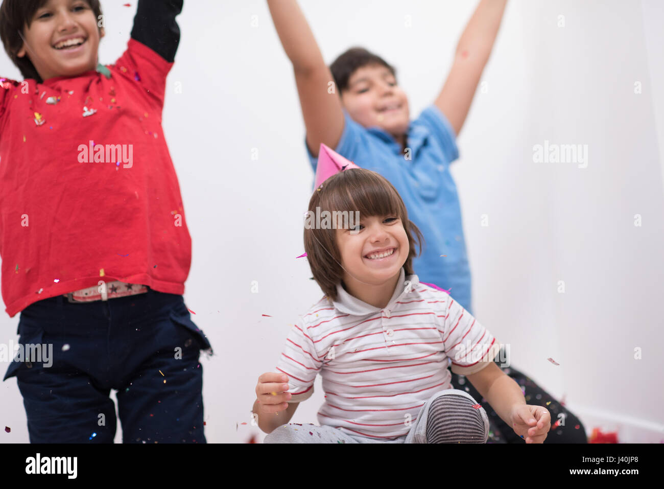 Happy kids celebrating party with blowing confetti Stock Photo - Alamy