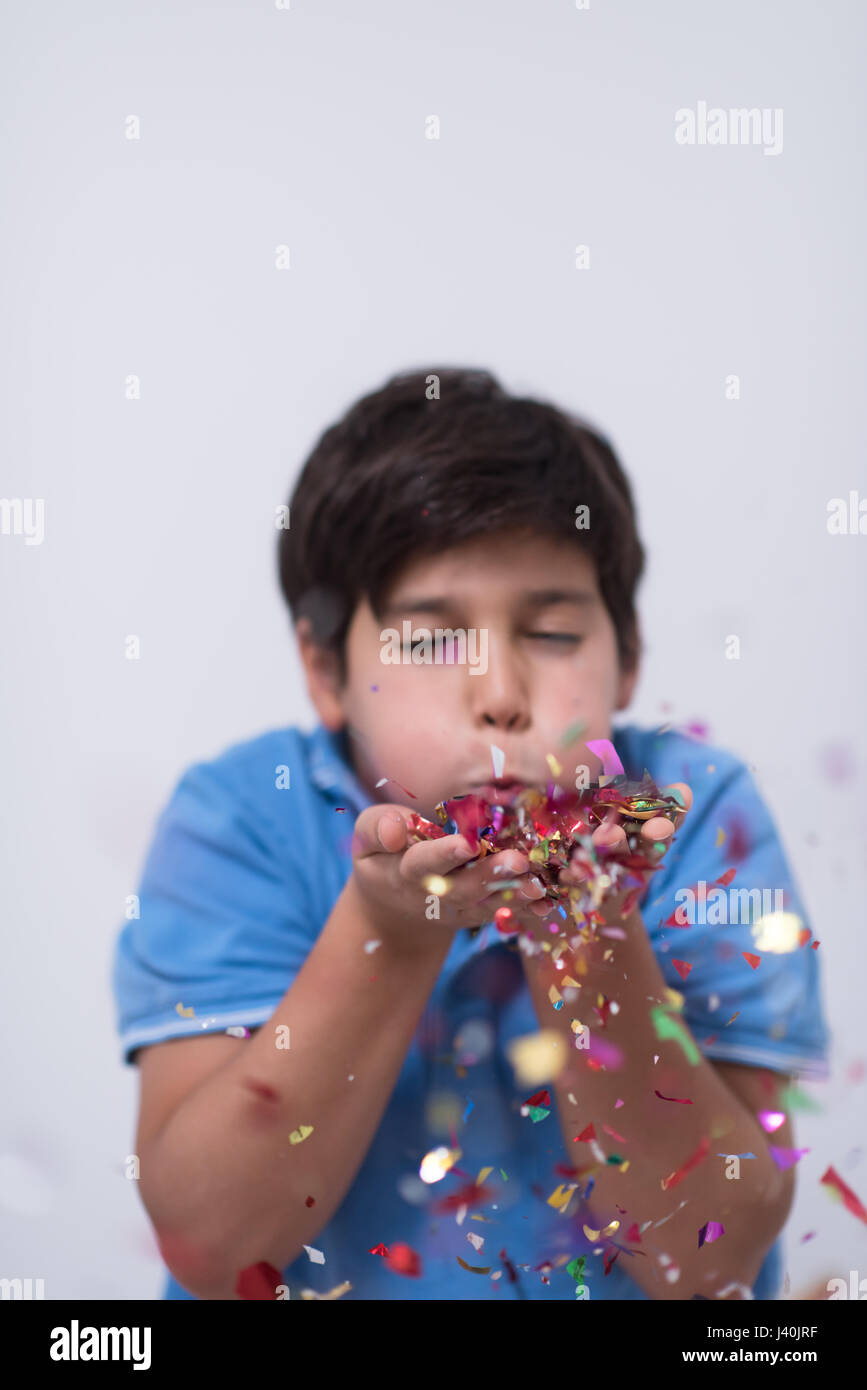 Happy kid celebrating party with blowing confetti Stock Photo - Alamy