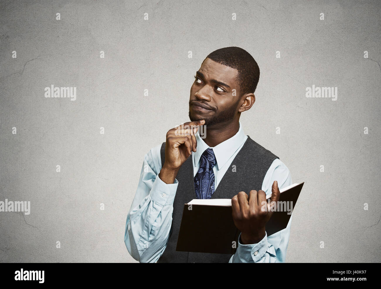 Closeup portrait confused, unhappy serious man holding, reading book ...