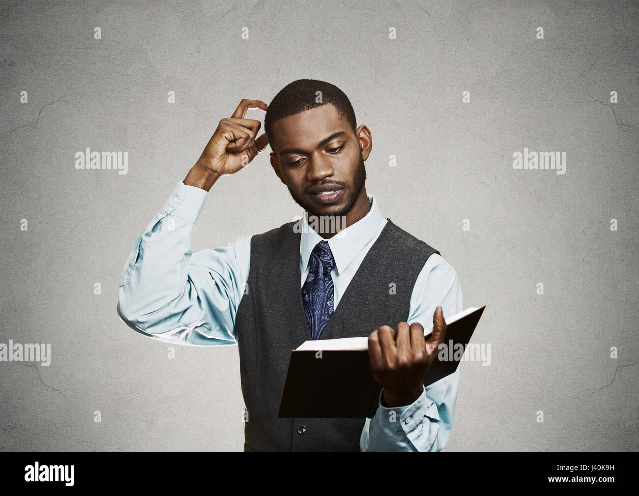 Closeup portrait confused, unhappy serious man holding, reading book ...