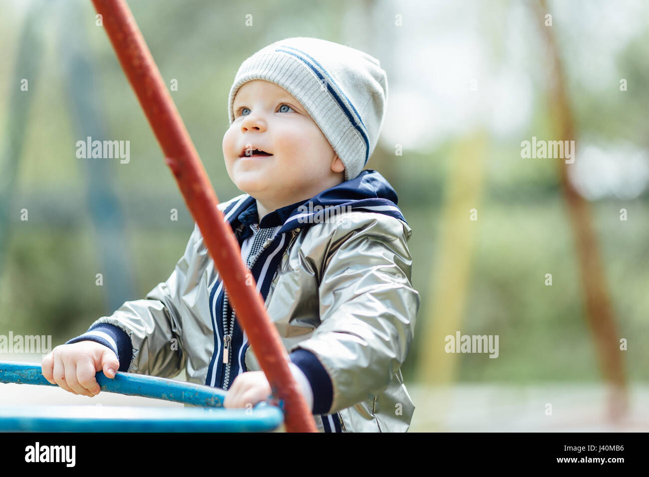 Little boy riding a swing in park playground spring Stock Photo - Alamy
