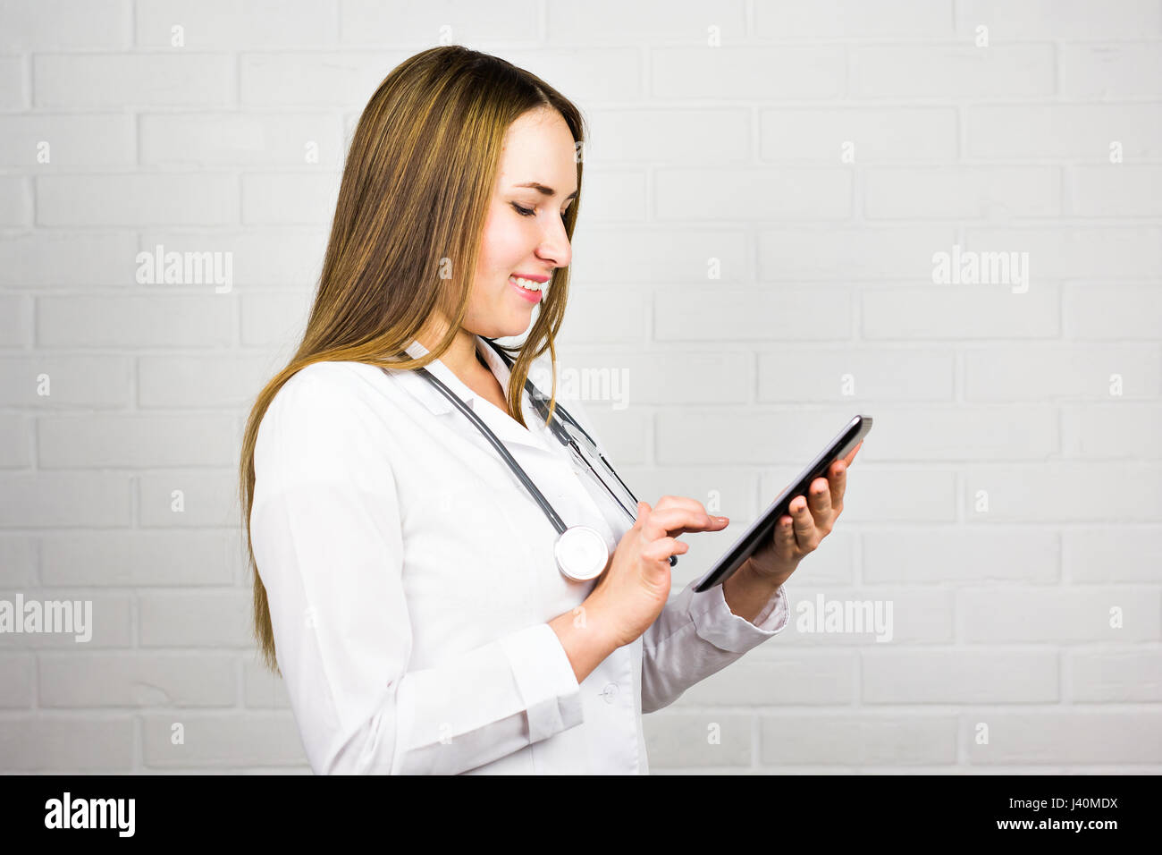 Smiling doctor using a tablet computer Stock Photo - Alamy