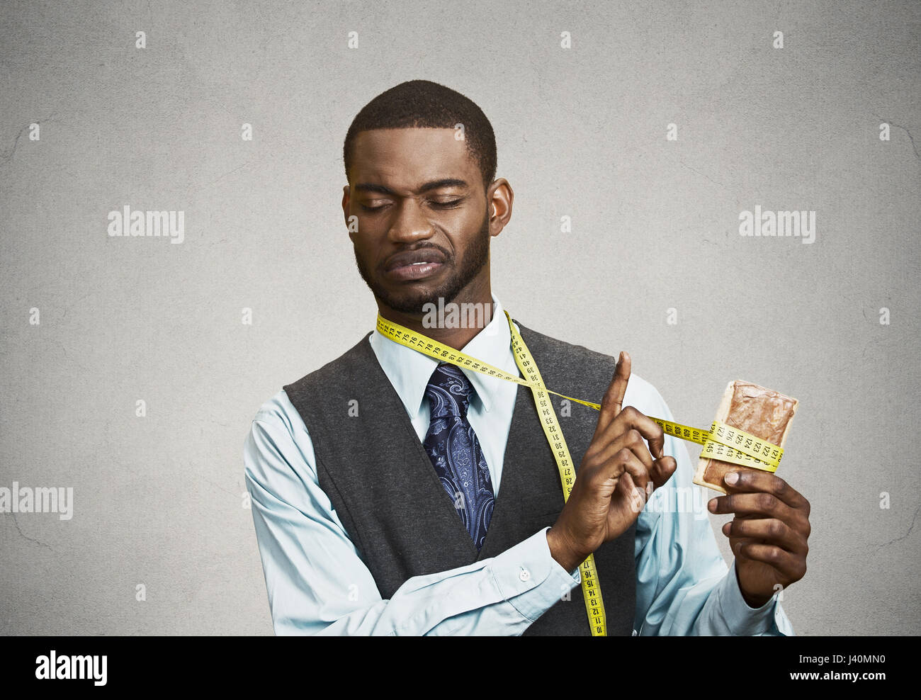 Closeup portrait funny young, confused man holding fatty, sweet cookie ...
