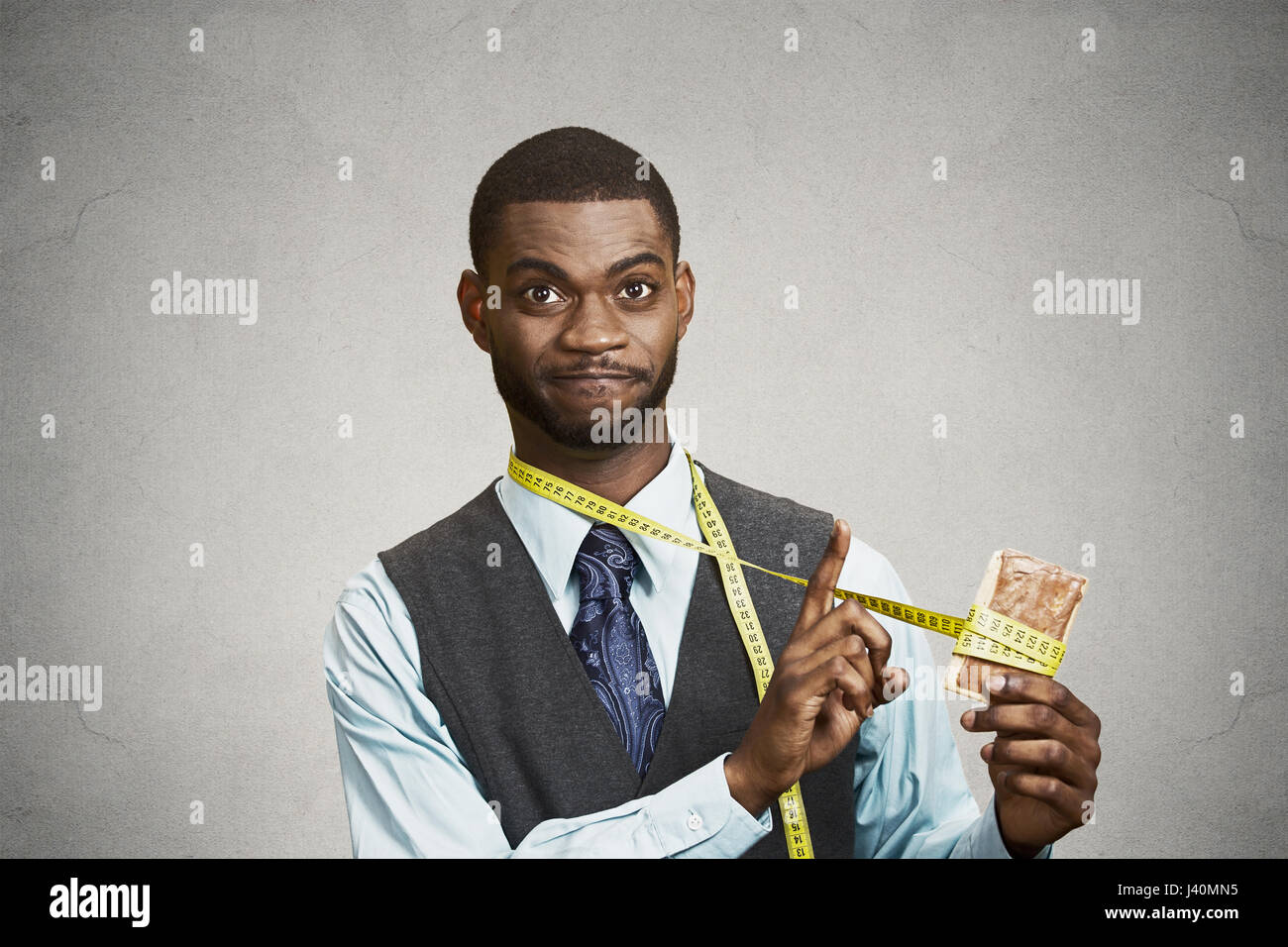 Closeup portrait funny young, confused man holding fatty, sweet cookie ...