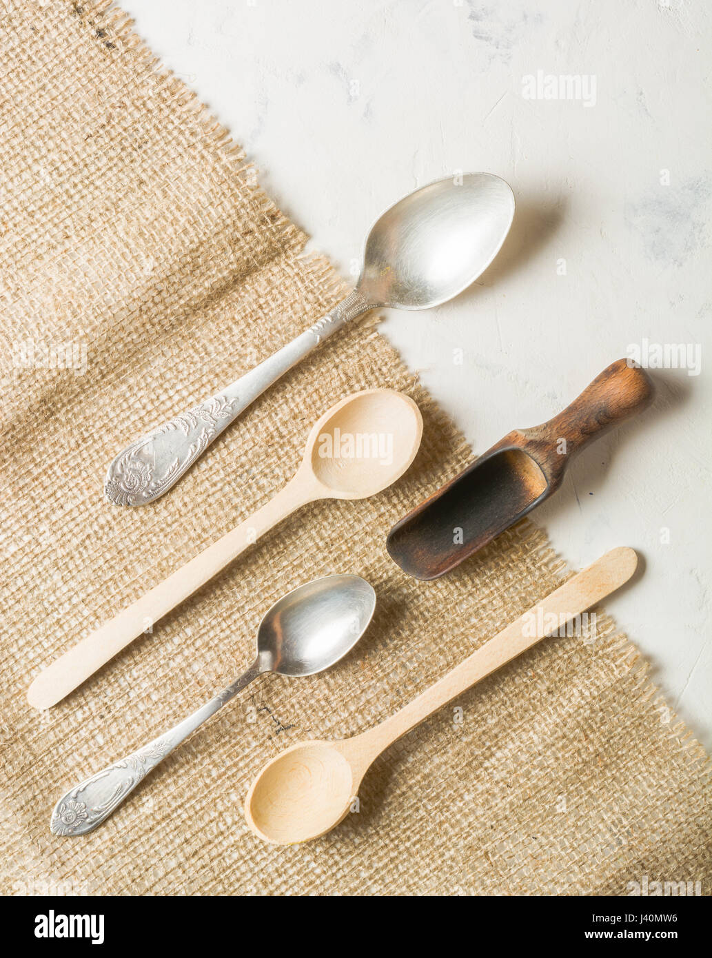 Different spoons made of wood and metal on a light background Stock ...