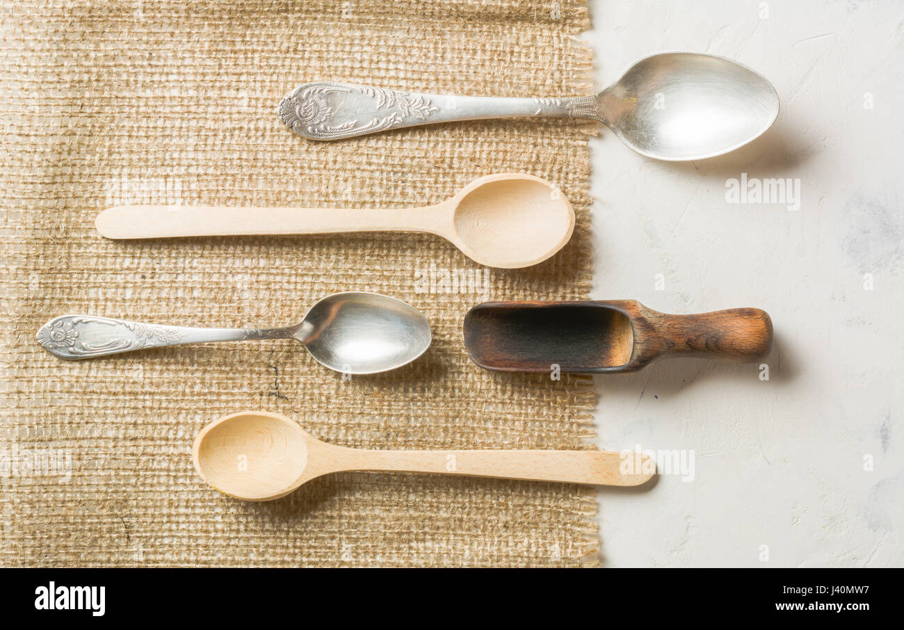 Different spoons made of wood and metal on a light background Stock ...