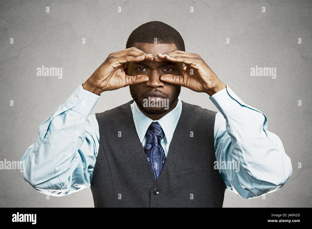 Portrait young handsome focused man looking curious, through fingers ...