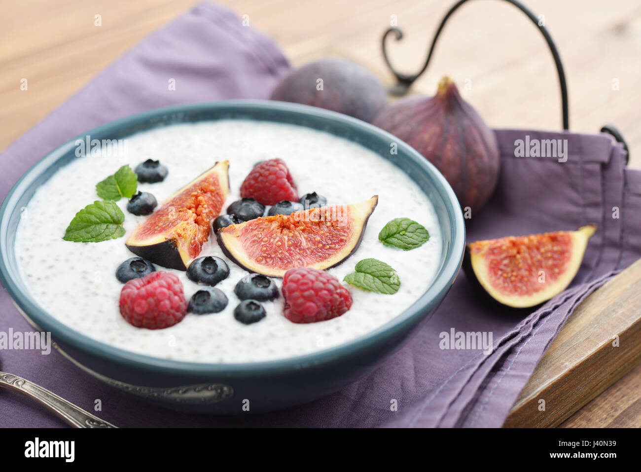 Chia seed pudding with figs, raspberry and blueberries in bowl on tray Stock Photo - Alamy