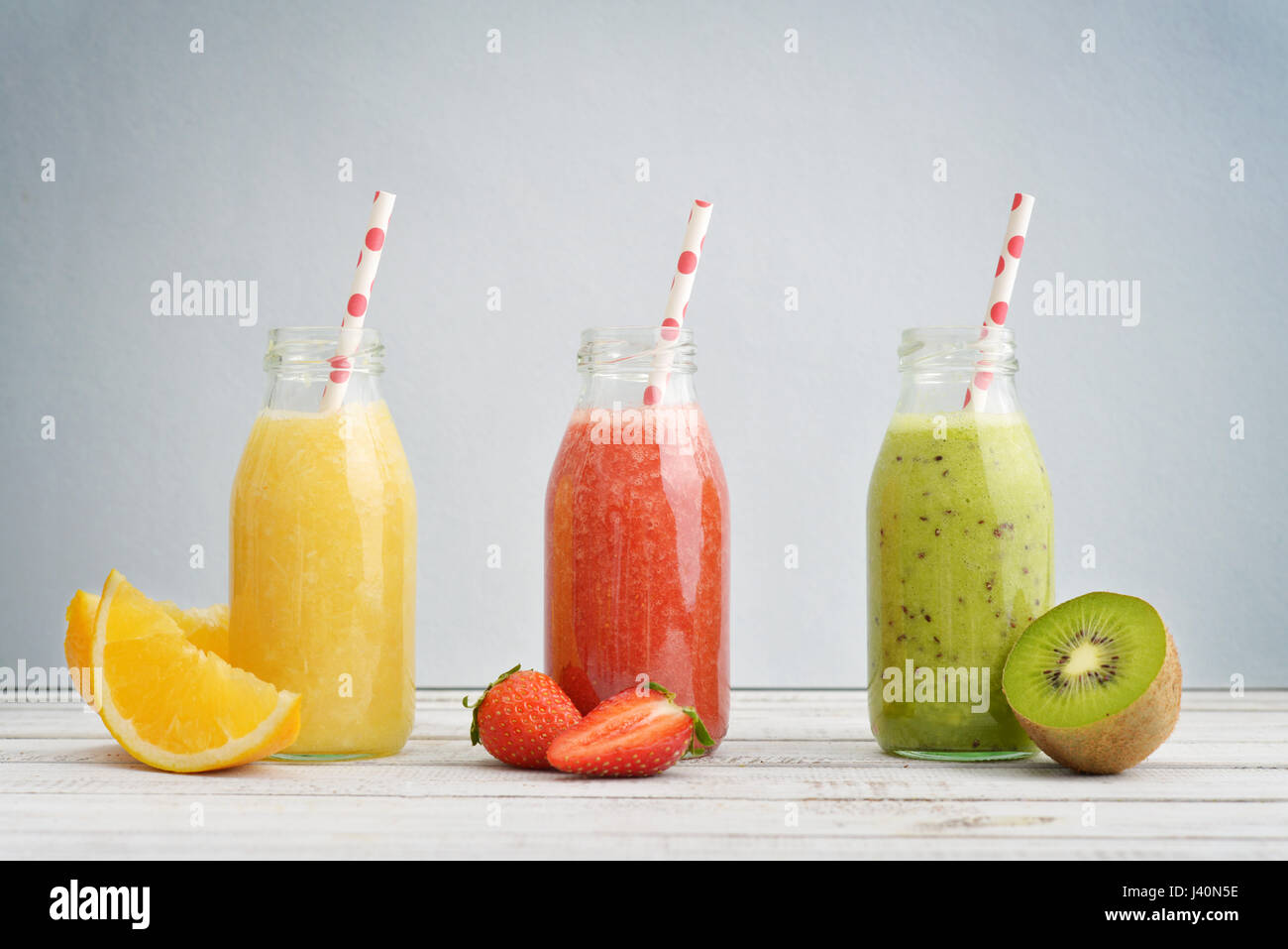 Fruit smoothies in retro bottles with strawberry, kiwi and orange on ...