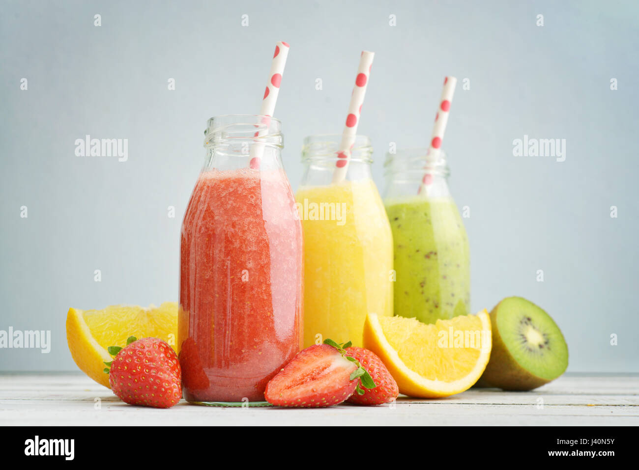 Fruit smoothies in retro bottles with strawberry, kiwi and orange on ...