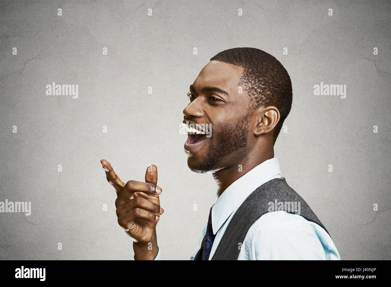 Closeup side view portrait, headshot young man, laughing, pointing with ...