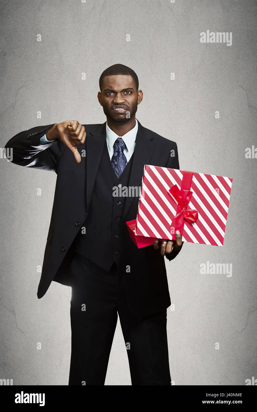 Closeup portrait grumpy unhappy upset man holding gift box displeased ...