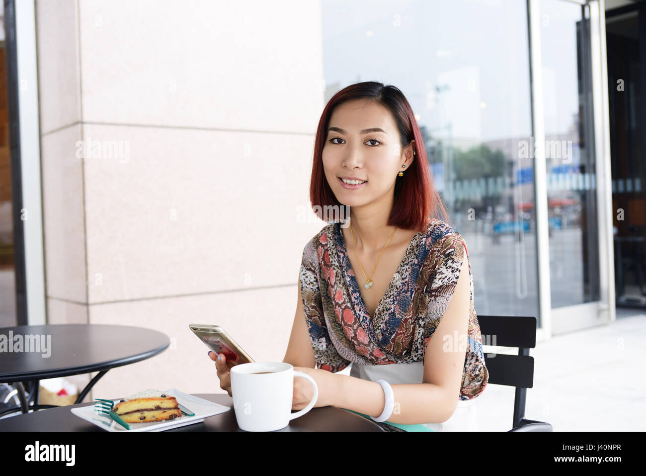 Smiling Woman Having Coffee at a Cafe Stock Photo - Alamy
