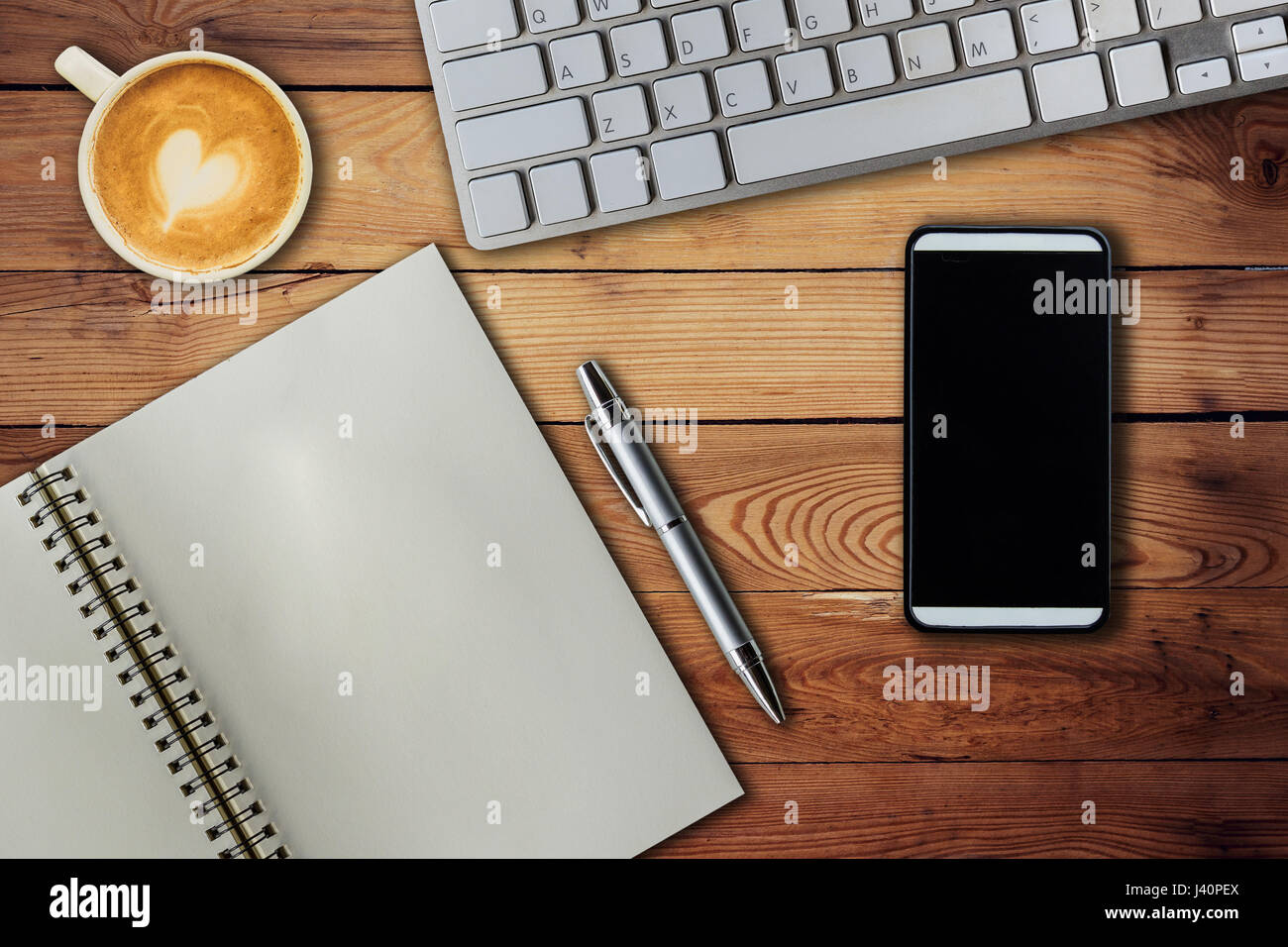 Mobile phone, notebook pen, keyboard computer and coffee cup on office ...