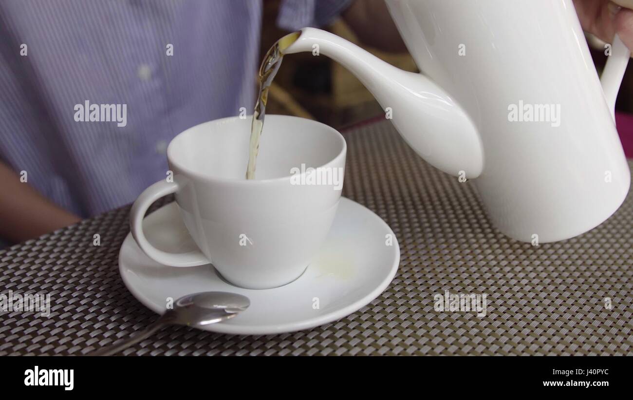 Close-up of woman pour the tea with teapot in cup. 4K Stock Photo - Alamy